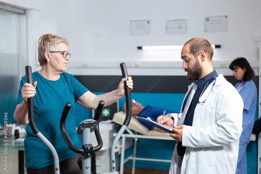 Photo & Art Print Old patient doing physical activity with stationary ...