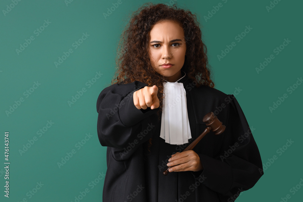 Poster Strict female judge with gavel pointing at viewer on color ...