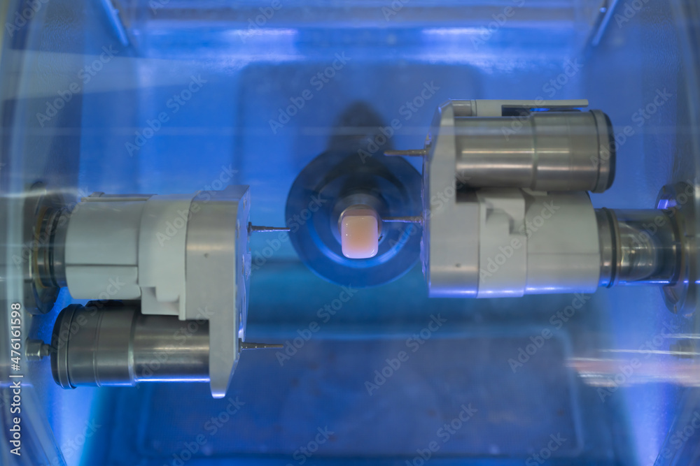 Dental milling machine carving out shape of human teeth close-up ...