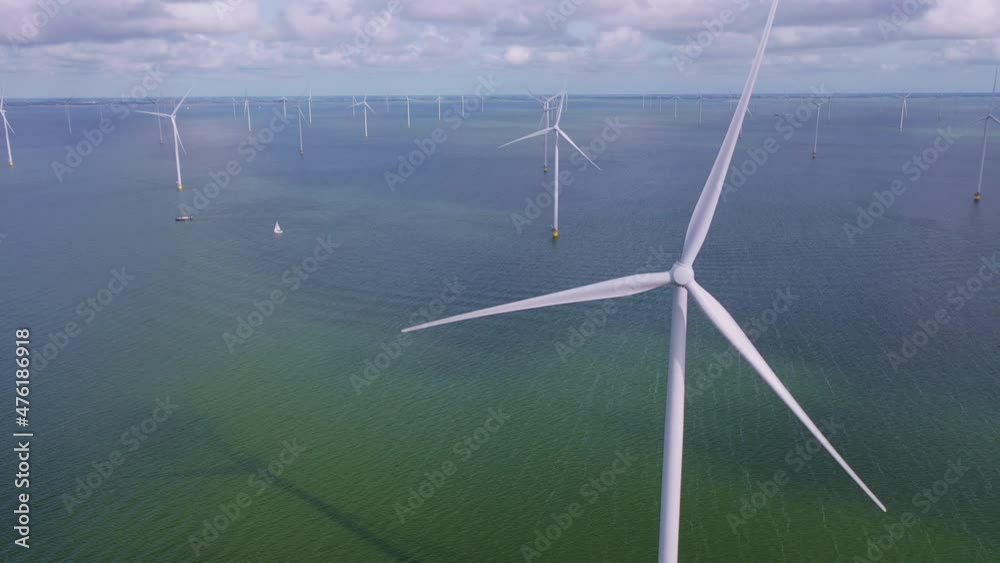 Aerial drone video of enormous windmills stand in the sea along a dutch ...
