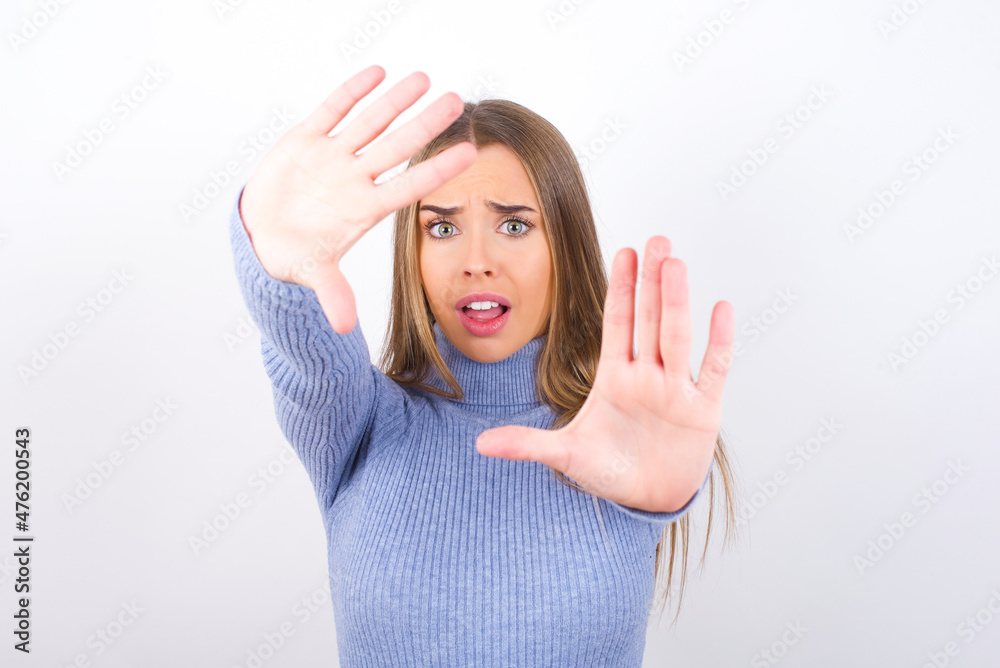 Dissatisfied Young caucasian girl wearing blue turtleneck over white ...