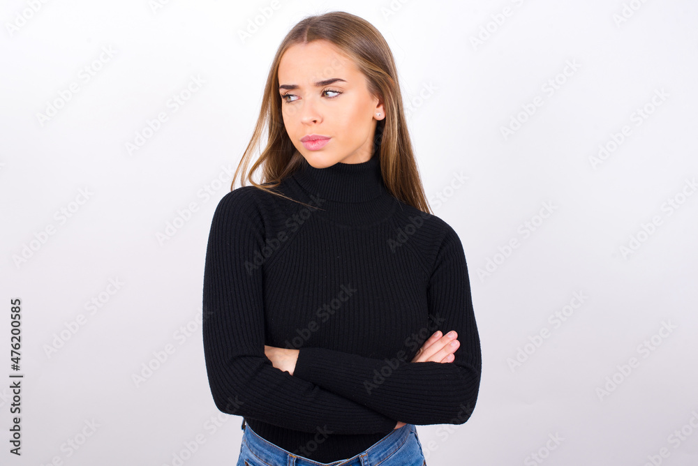 Displeased Young caucasian girl wearing black turtleneck over white ...