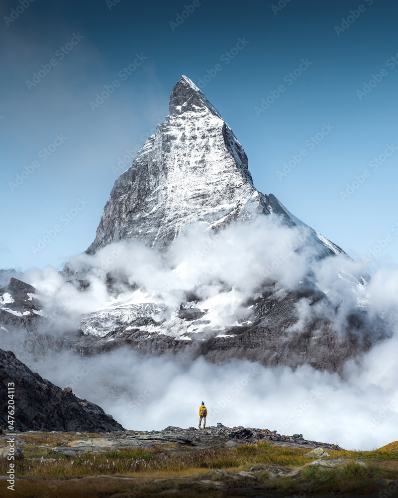 Hiker man walks alone through the incredible Swiss Alps with the ...
