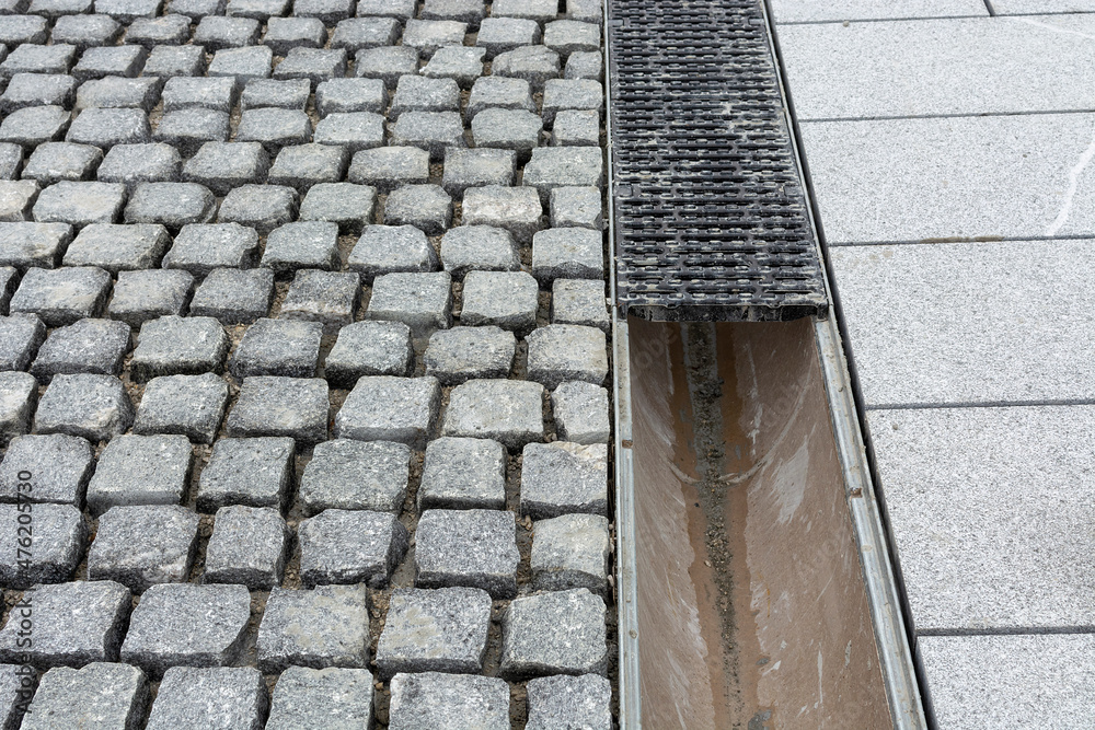 stormwater drainage channel with paved streets on both sides, different ...
