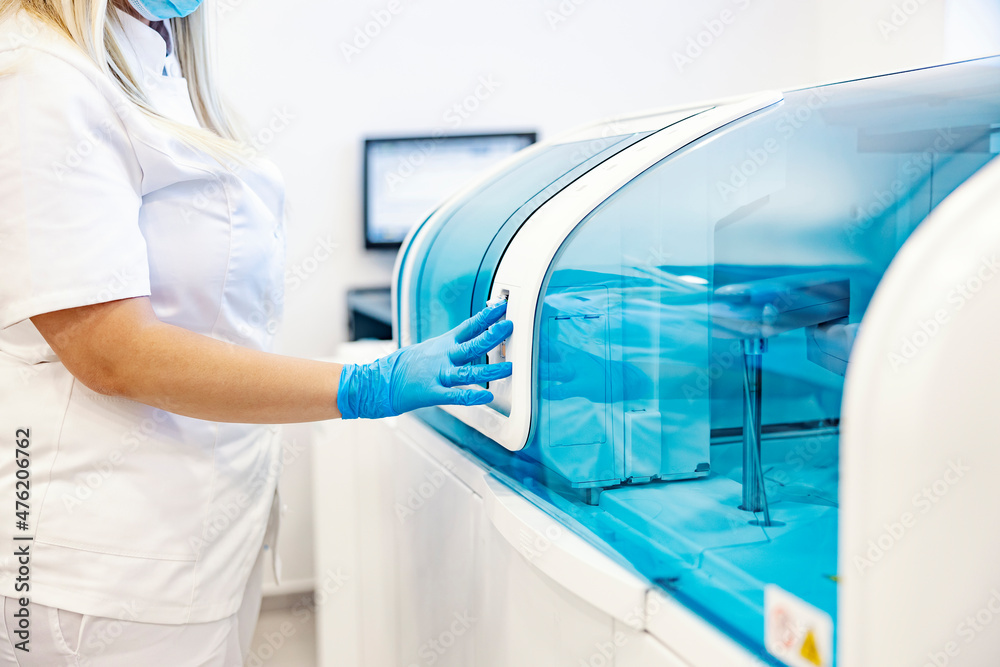 Modern machine in a lab. A nurse standing next to a machine for ...