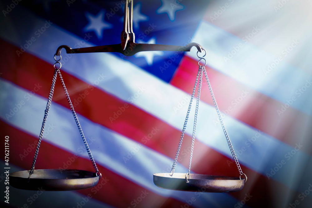 Scale of Justice in the rays of light against American flag background ...