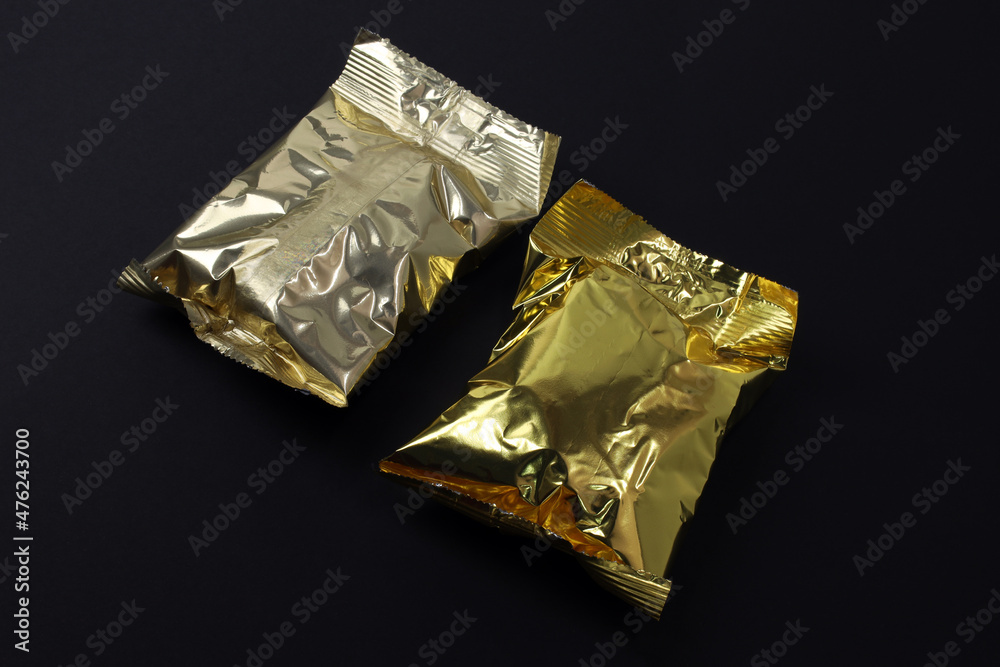Foil bags for sweets on a black background. Small foil bags. Plastic ...