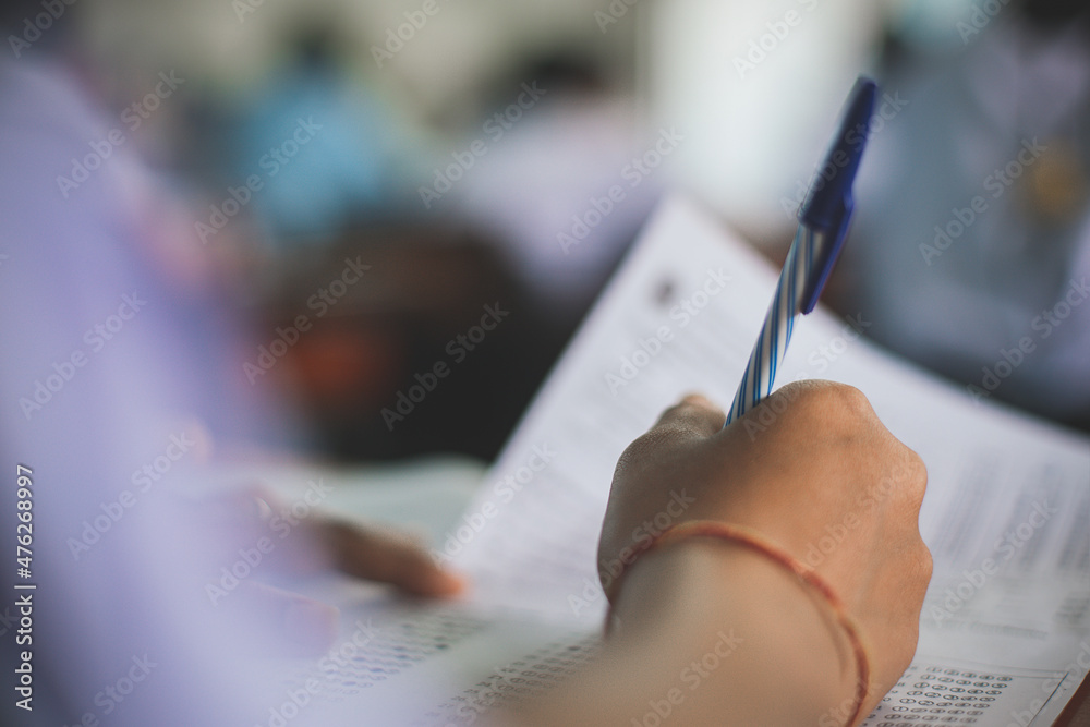 Students writing and reading exam answer sheets exercises in classroom ...