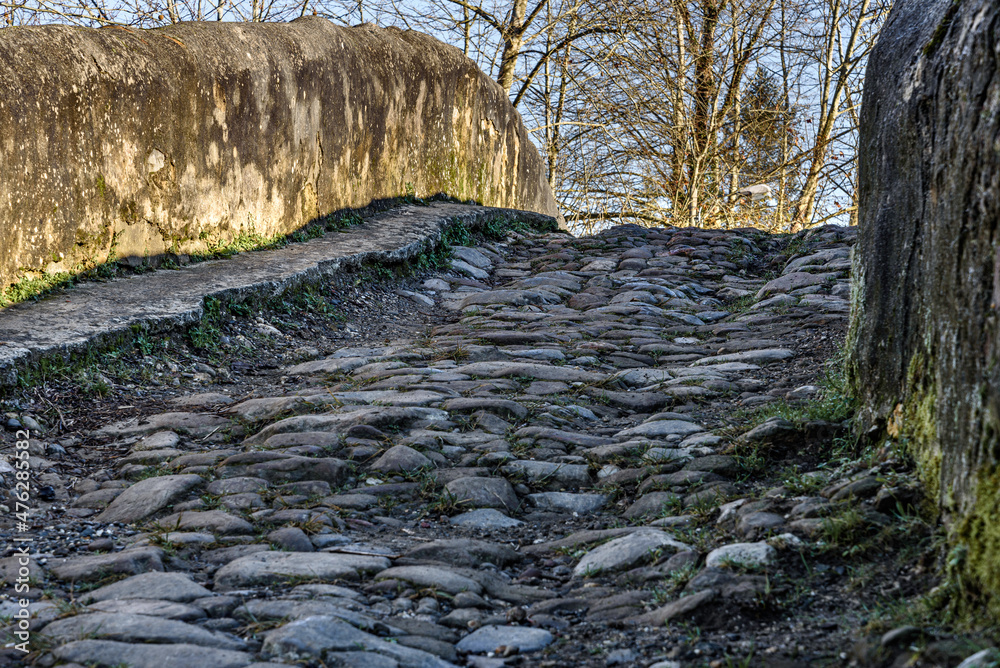 Stone path over the medieval bridge of the Camino de Santiago. Pebble ...