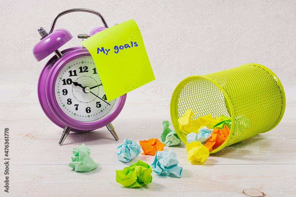 There is an alarm clock with a sticker on the table. My goals are ...