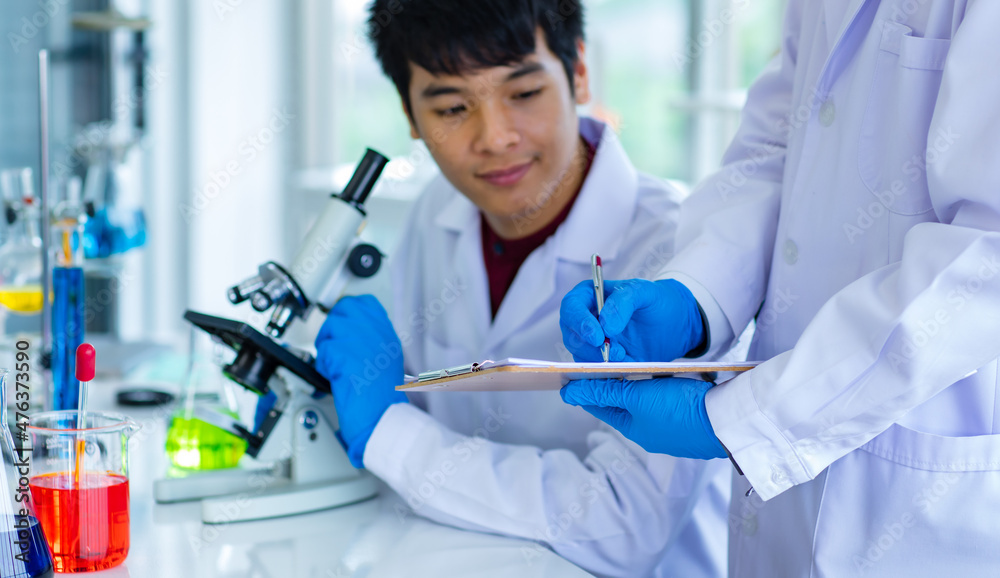 Asian young university male scientist student in white lab coat safety ...