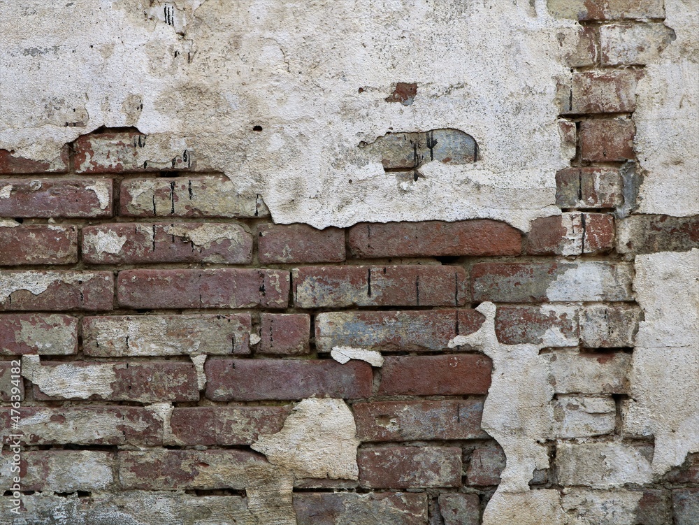 old dilapidated brick wall with layers of plaster as an antique ...