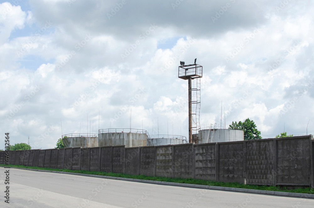 Old dirty oil storage tanks behind the concrete fence Stock Photo ...