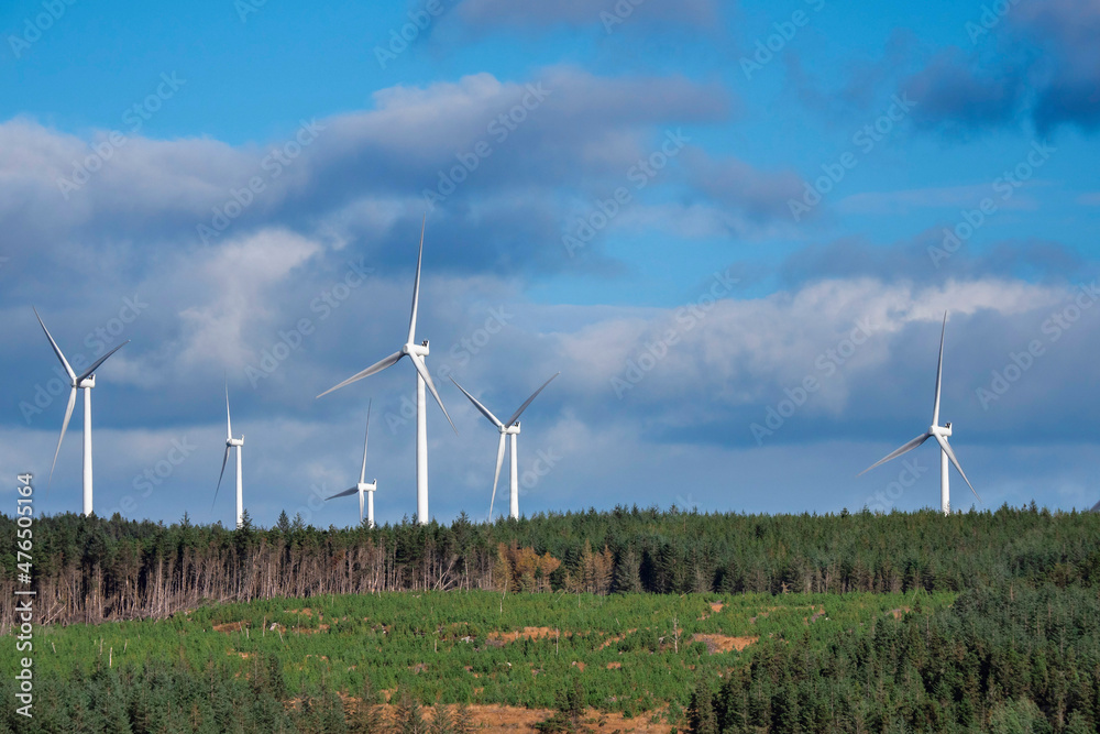 Green forest with wind energy turbines. Blue cloudy sky. Incorporating ...