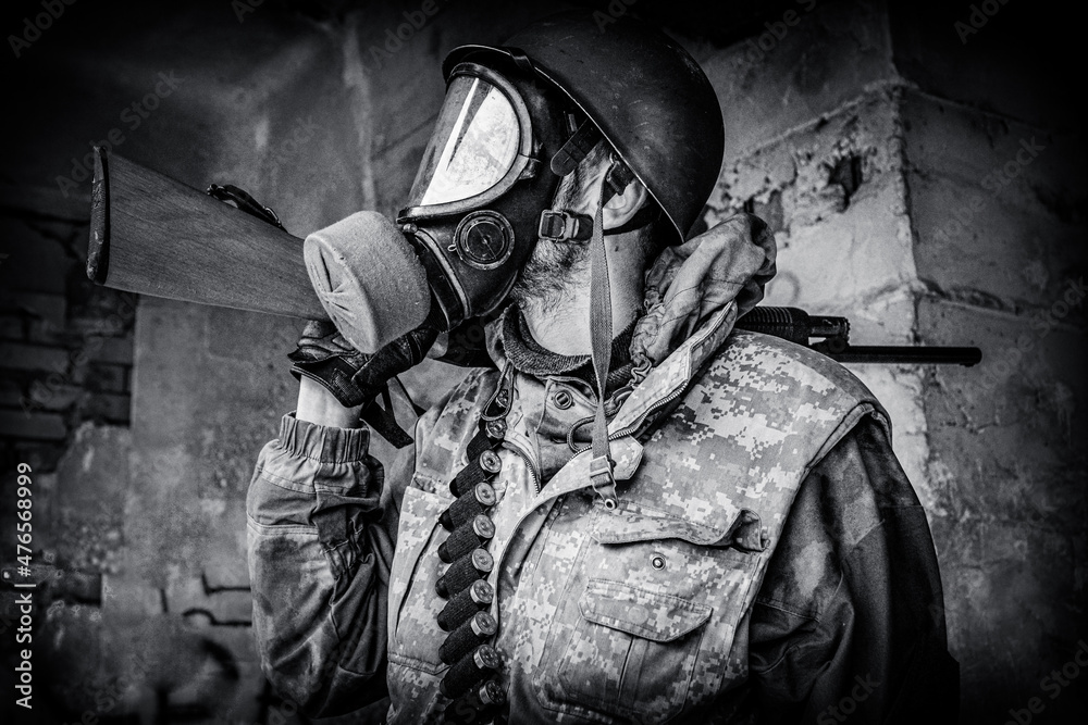 A masked soldier armed with a silenced assault rifle is about to fire ...