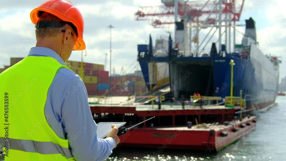 Cargo ship loading in dock. Port manager with hardhat and glasses ...