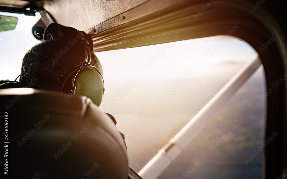 Rear view of pilot and copilot in private cockpit of small airplane ...