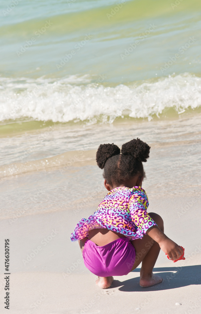 back view, close distance of a black female child, in a purple bathing ...
