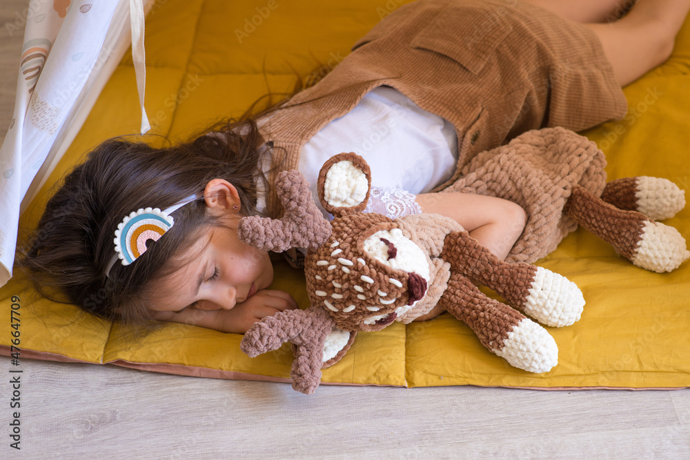 little girl sleeps with a soft toy. cute little girl hugging a toy deer ...