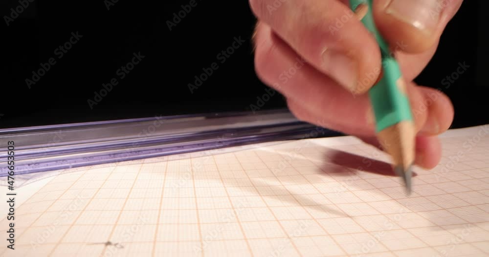 Drawing a pencil line on the ruler on the drawing sheet. Close-up of ...