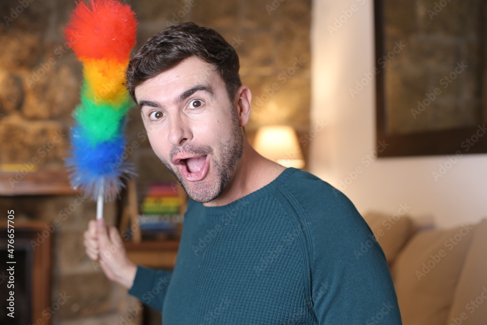 Cute man holding feather duster with the rainbow colors Stock Photo ...