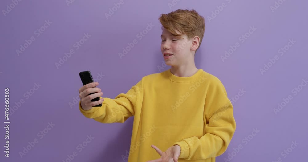 portrait of nice caucasian teenage boy talking on video call with ...