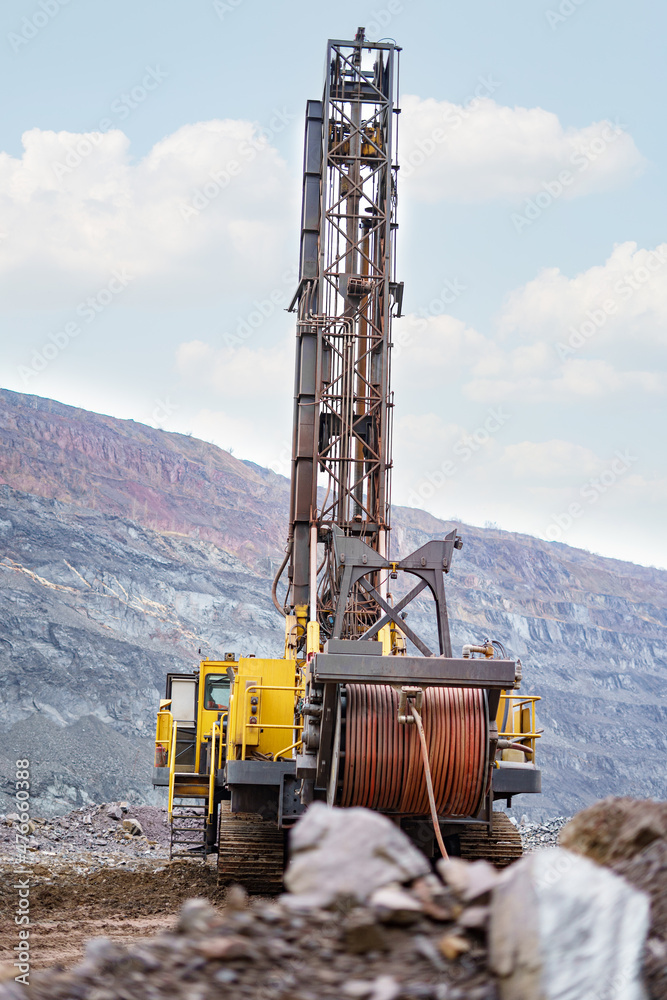 Large drill rig in an ore quarry. Preparation of boreholes for laying ...