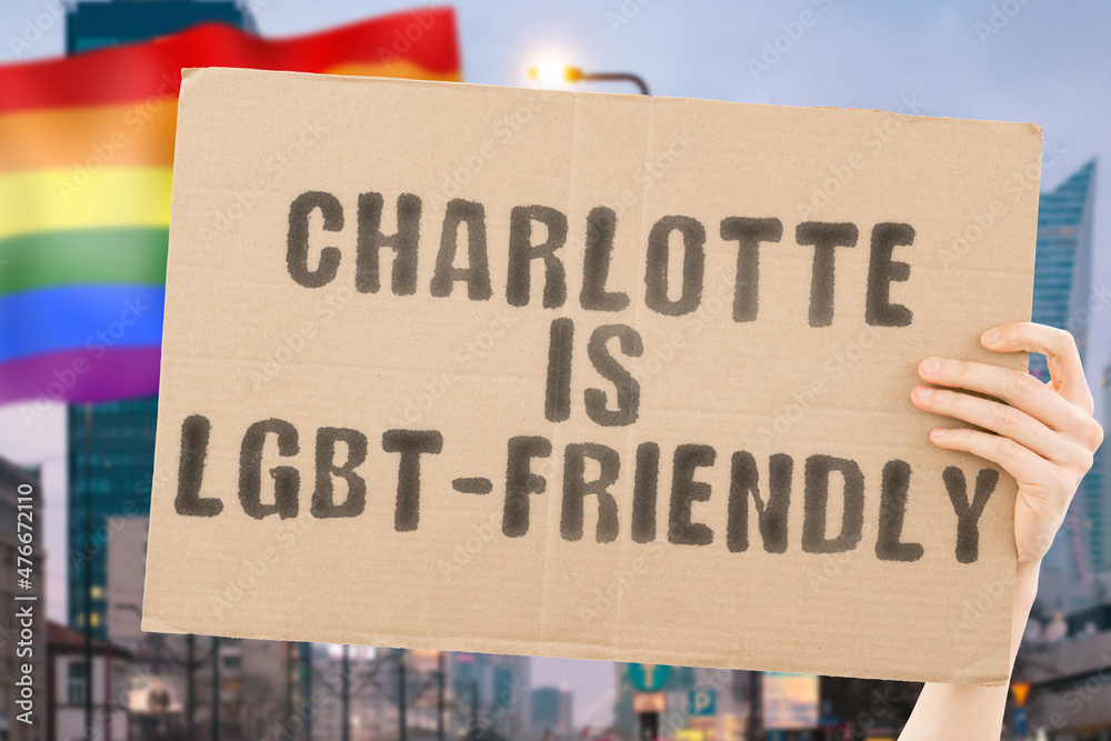 The phrase " Charlotte is LGBT-Friendly " on a banner in men's hand ...