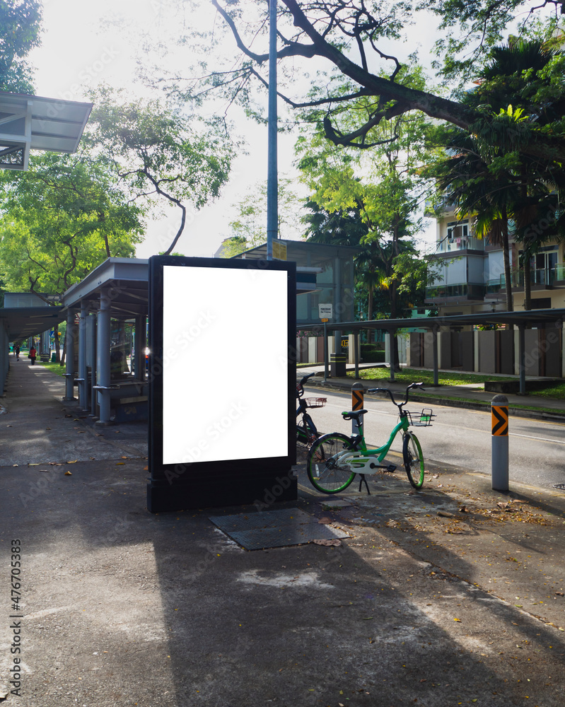 Vertical bus stop billboard ad mock up in a residential area surrounded ...