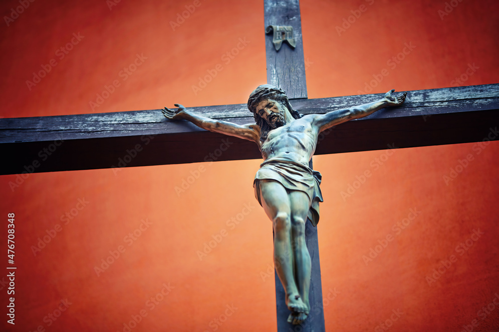 Catholic cross with crucified Jesus Christ statue over rough background. Crucifixion. Jesus ...