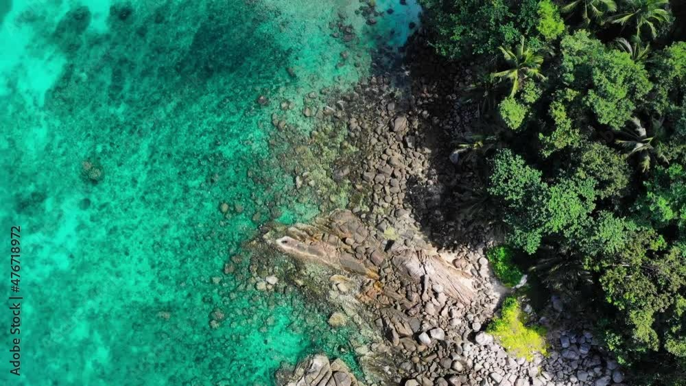 Flying slowly above Coral reefs on the shore of uninhabited island in ...