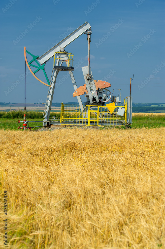 Foto de Wheat field. Pumpjack. The rocker is an overhead drive for a ...