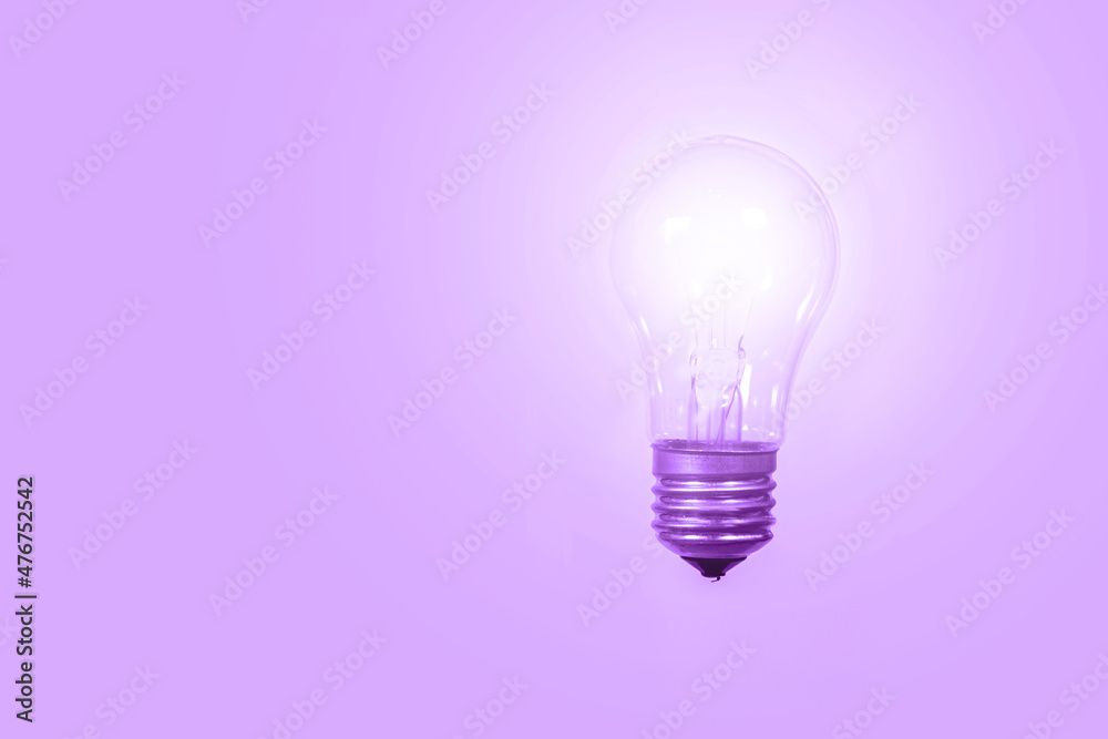 Glowing light bulb on a purple background, color very peri trendy 2022 ...