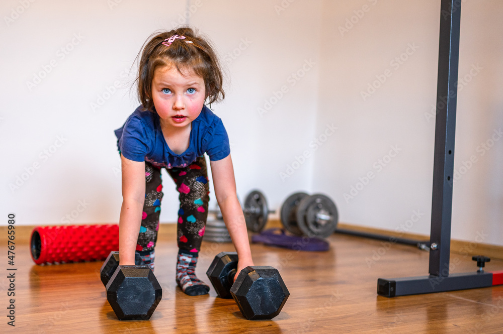 A four-year-old girl is doing calisthenics workout in home gym. Stock ...