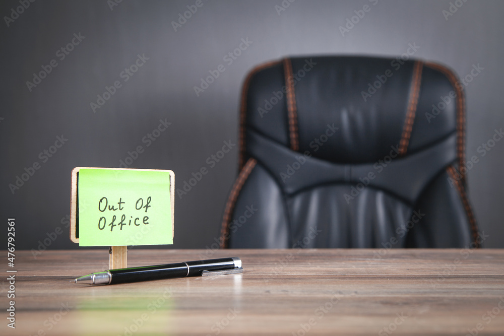 Out of office message on sticky note on the desk. Stock Photo | Adobe Stock