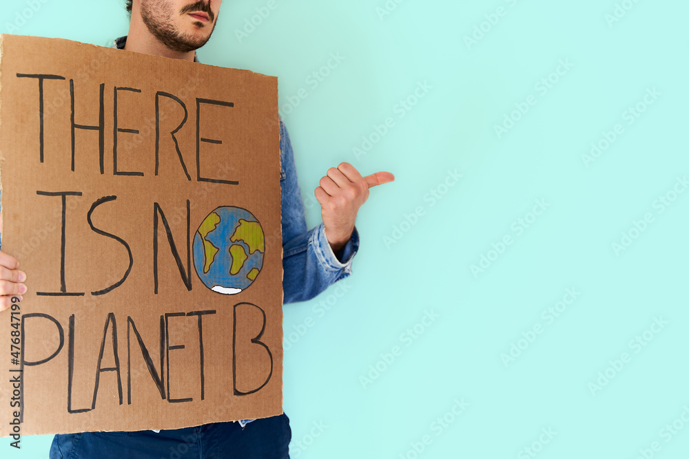 Stop climate change concept. Climate activist holding there is no planet b sign over turquoise ...