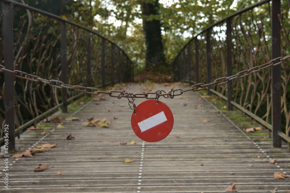 Typical white bar on red background no entry sign hanging crooked on a ...
