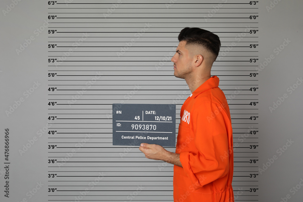 Prisoner with mugshot letter board at police department Stock Photo ...