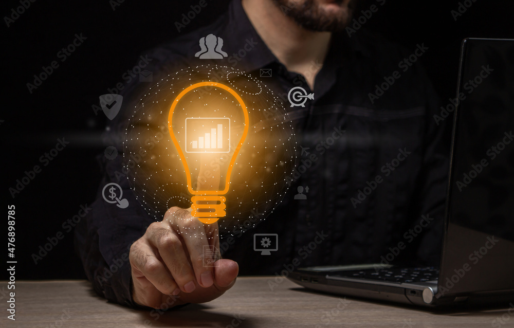A businessman chooses a light bulb icon as a symbol of inspiration and ...