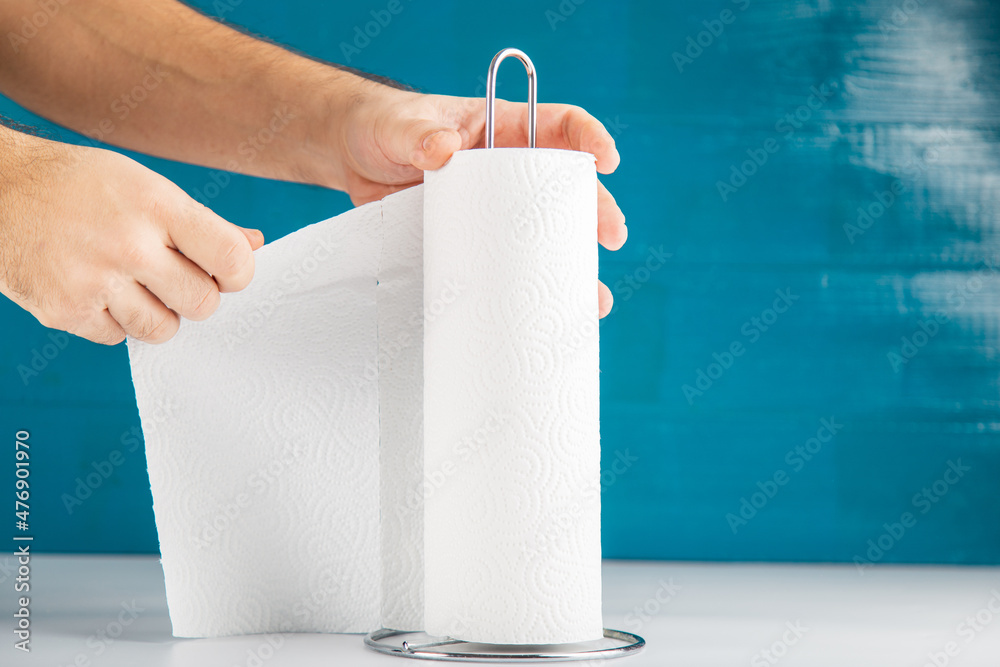 an anonymous hand is tearing off paper towel, hygiene concept copy ...