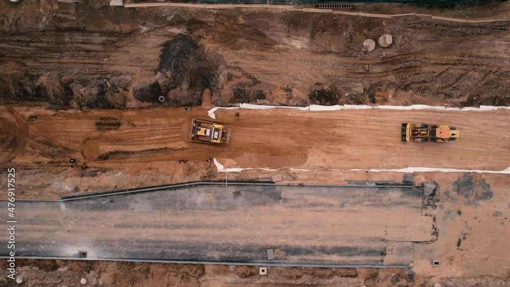 Dozer levels the ground during road construction, aerial view ...
