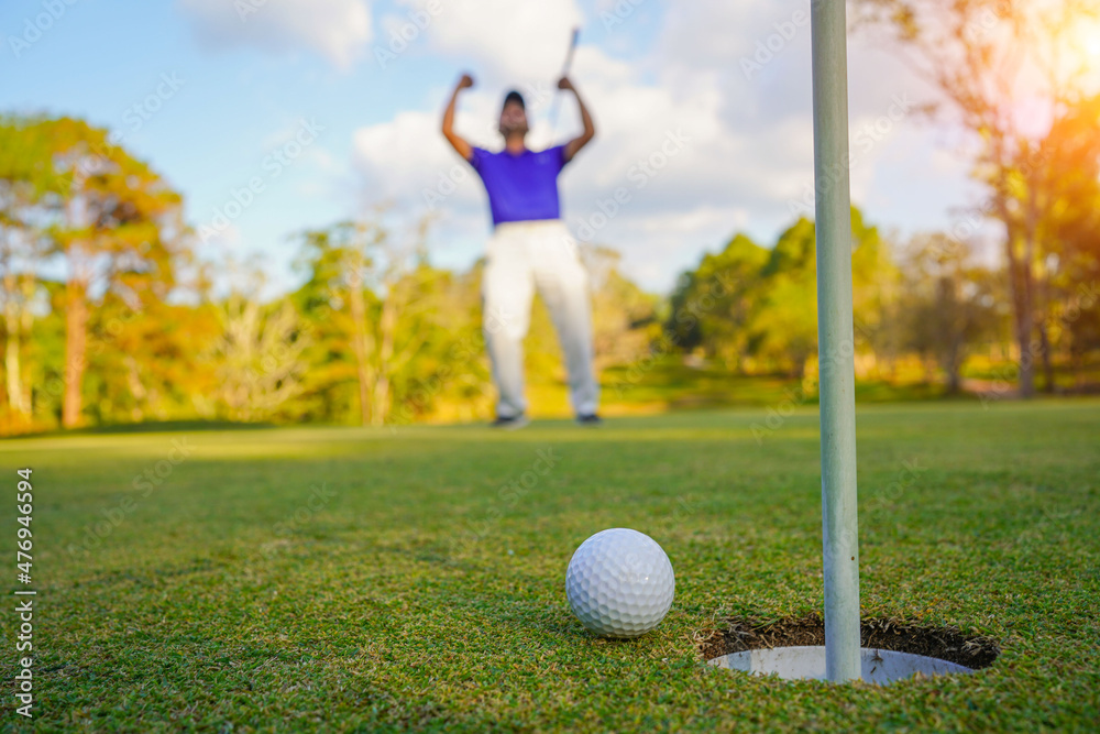 Golfer action to win after long putting golf ball on the green golf ...