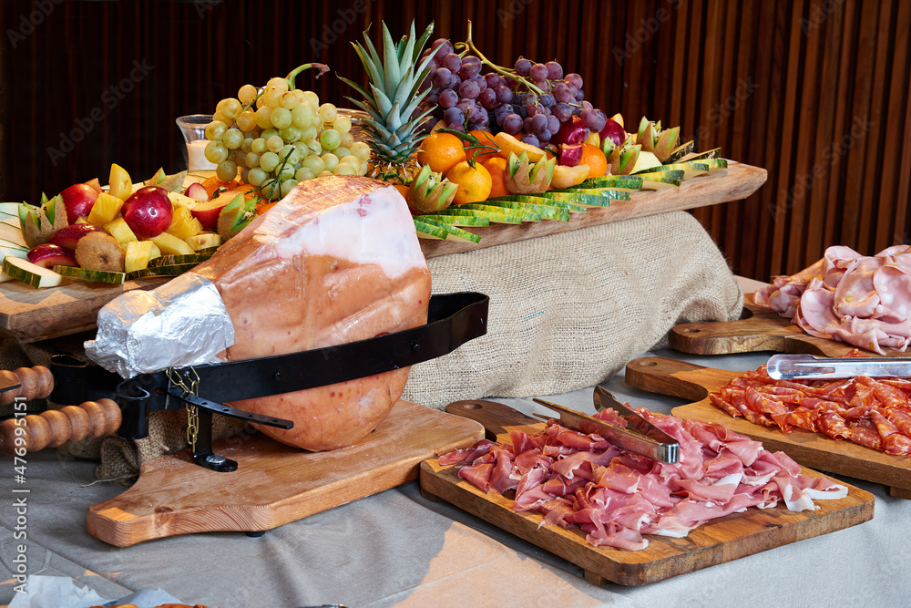Colored buffet with seasonal fresh fruits and different kind of Ham ...