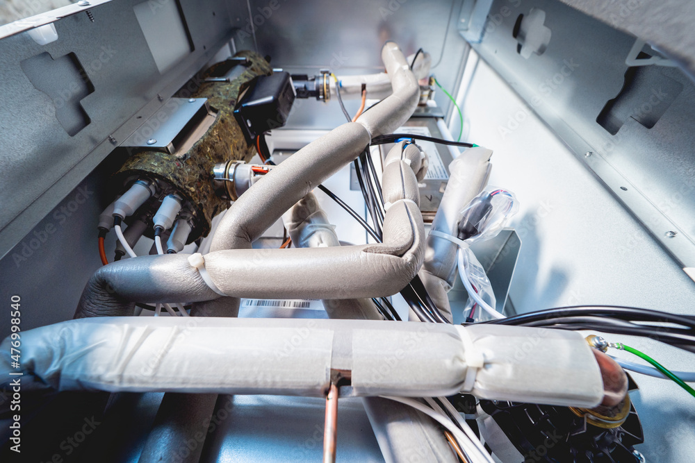 Open air conditioner unit with wires, pipes and electrical equipment ...