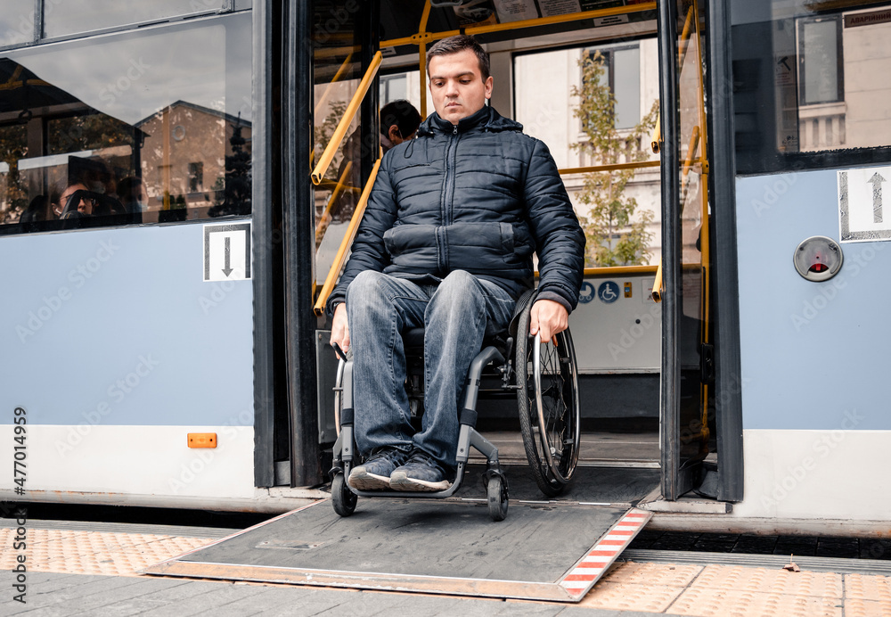 Person with a physical disability exits public transport with an ...
