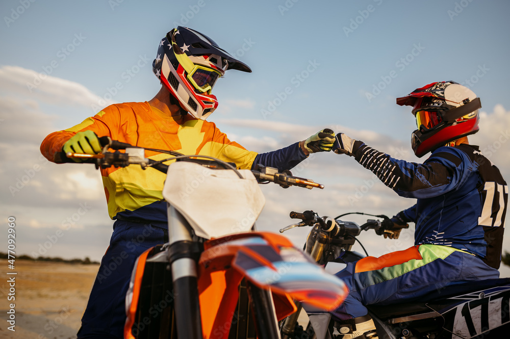 Motocross riders hitting fists for good luck Stock Photo | Adobe Stock