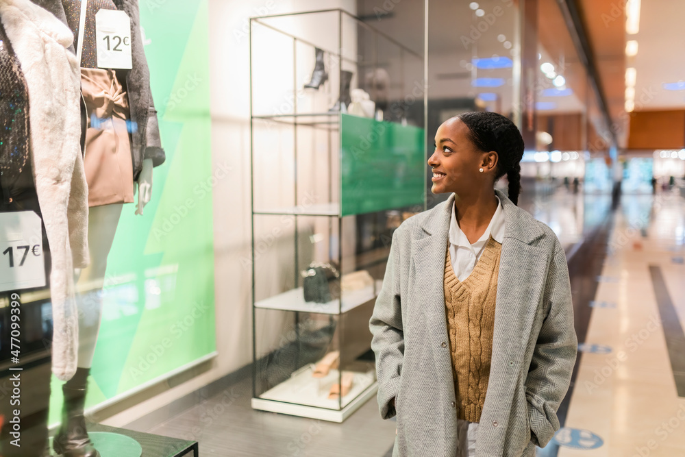 Smiling teenage girl window shopping in mall Stock Photo | Adobe Stock