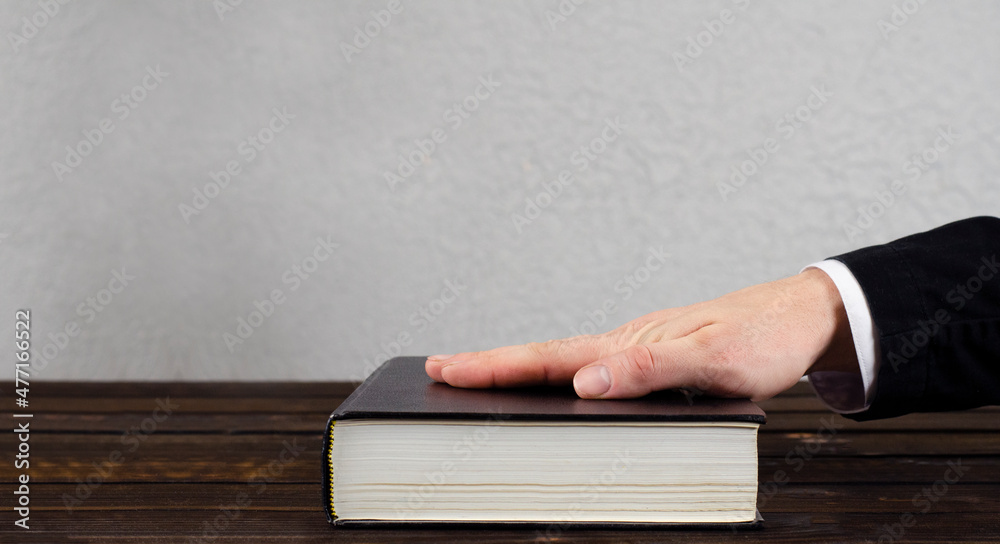 The oath. Hand on the Bible. The man in the shirt put his hand on the ...