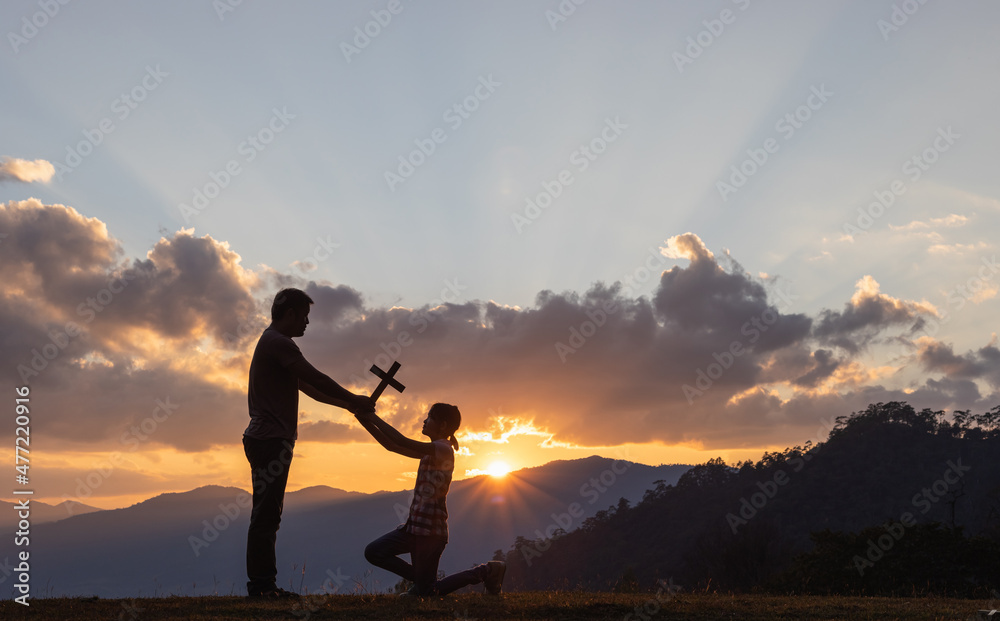 Silhouette Christian father holding Christian cross teaching his ...