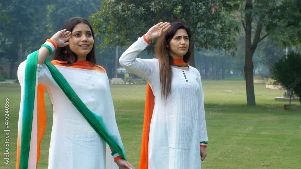 Two young women happily saluting the Indian National Flag while ...